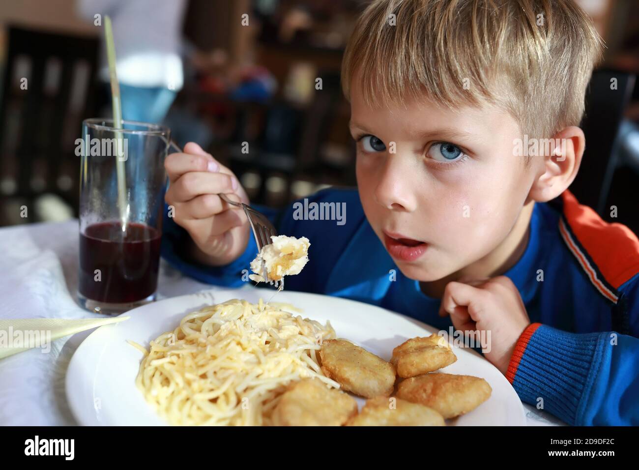 Child eating nuggets with spaghetti in restaurant Stock Photo - Alamy