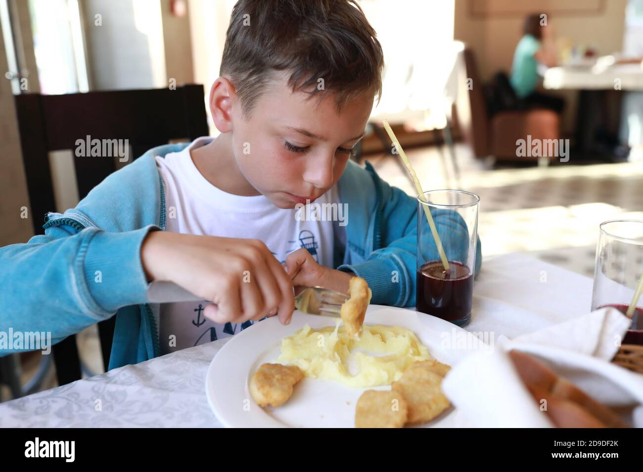 Child eating nuggets with mashed potatoes in restaurant Stock Photo - Alamy