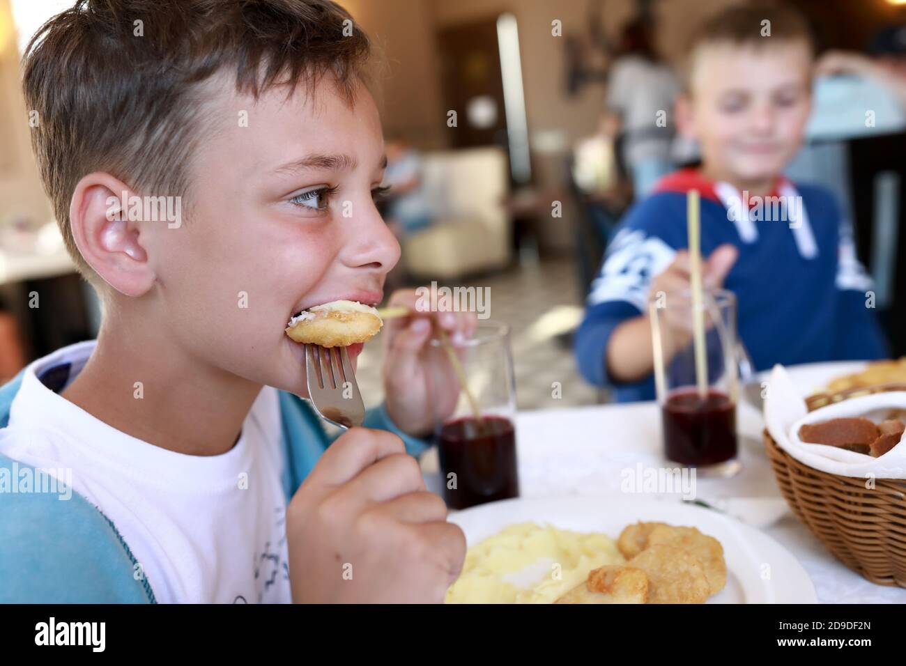 Two kids eating nuggets in a restaurant Stock Photo - Alamy