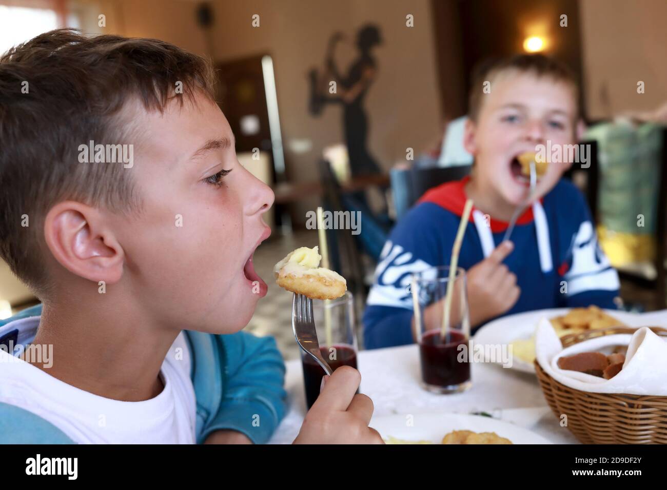 Two children eating nuggets in a restaurant Stock Photo - Alamy