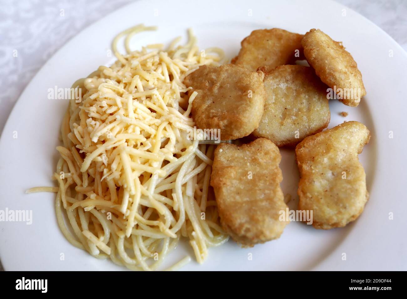 Nuggets with spaghetti on plate in restaurant Stock Photo - Alamy