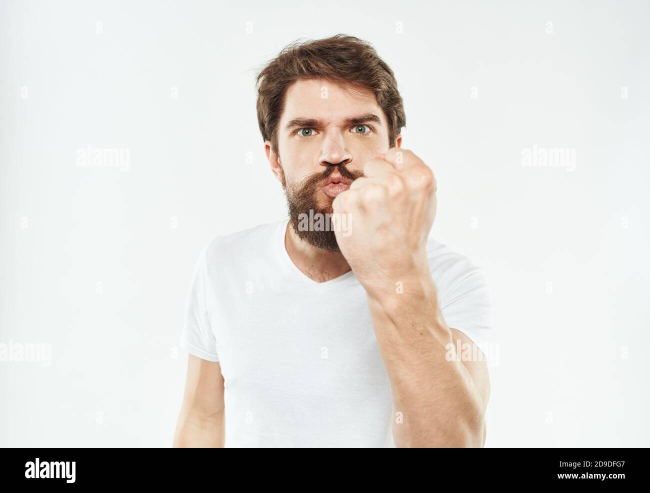 Aggressive man gestures with his hands on a light background and a ...