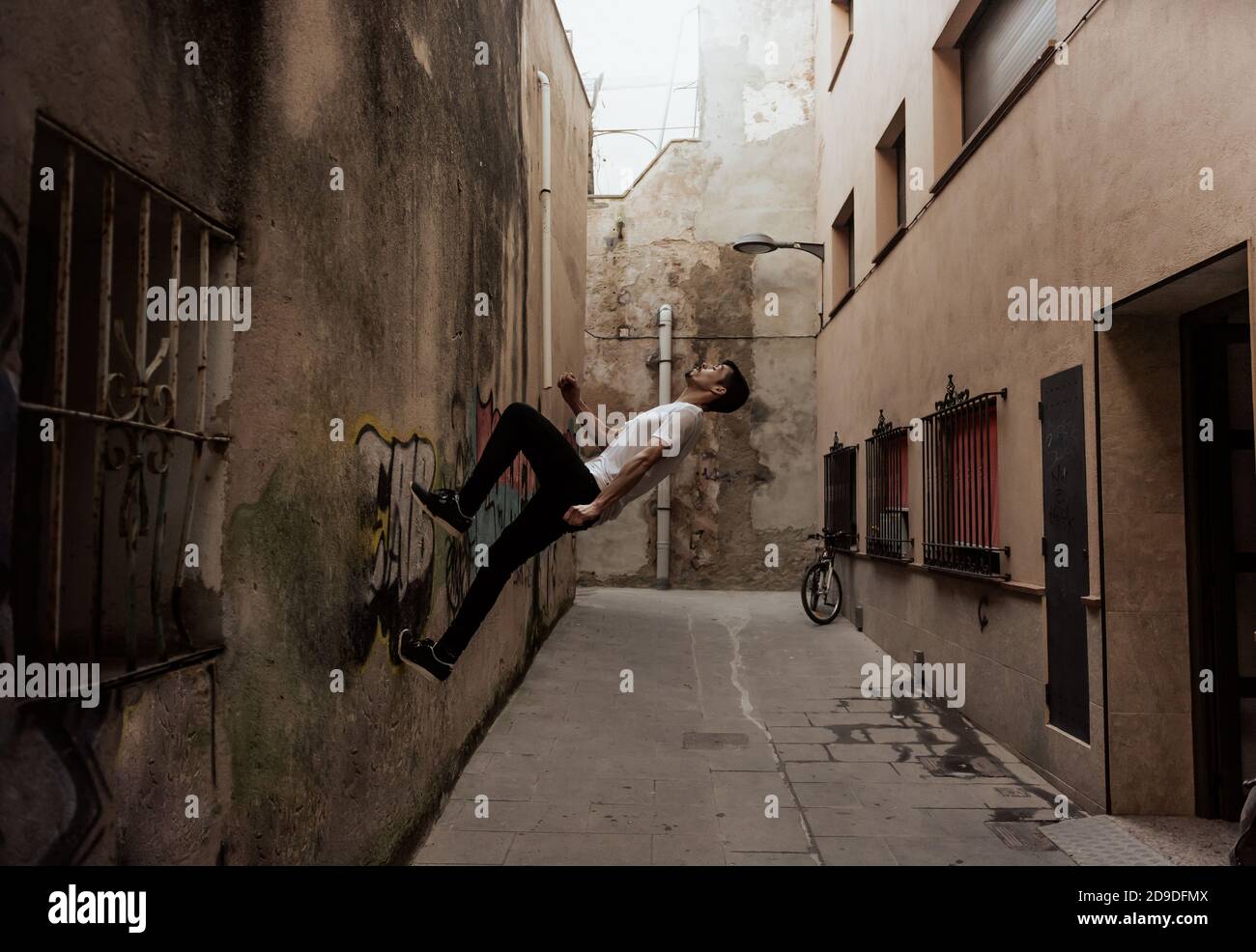 young sportsman practicing parkour, acrobatics and deadly jumps in the ...