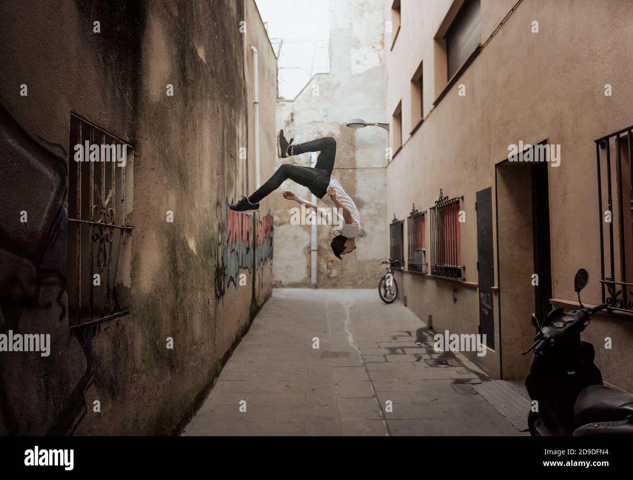 young sportsman practicing parkour, acrobatics and deadly jumps in the ...