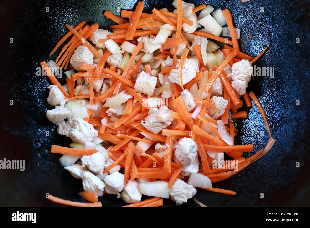Frying meat with onions and carrots in cauldron for pilaf Stock Photo ...