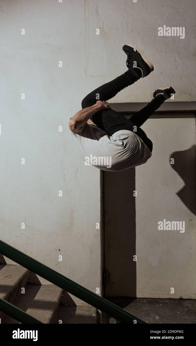 young sportsman practicing parkour, acrobatics and deadly jumps in the ...