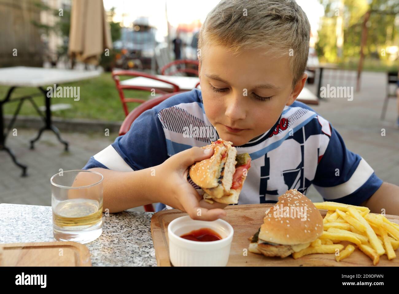 Child in cafe eating hamburger hi-res stock photography and images - Alamy