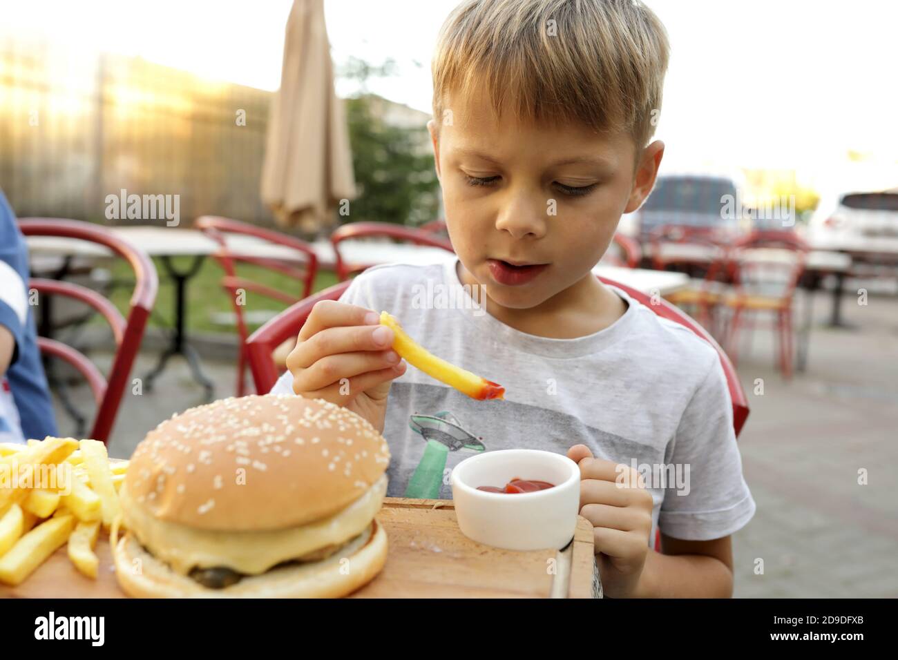 Child eating fries with ketchup in restaurant Stock Photo - Alamy
