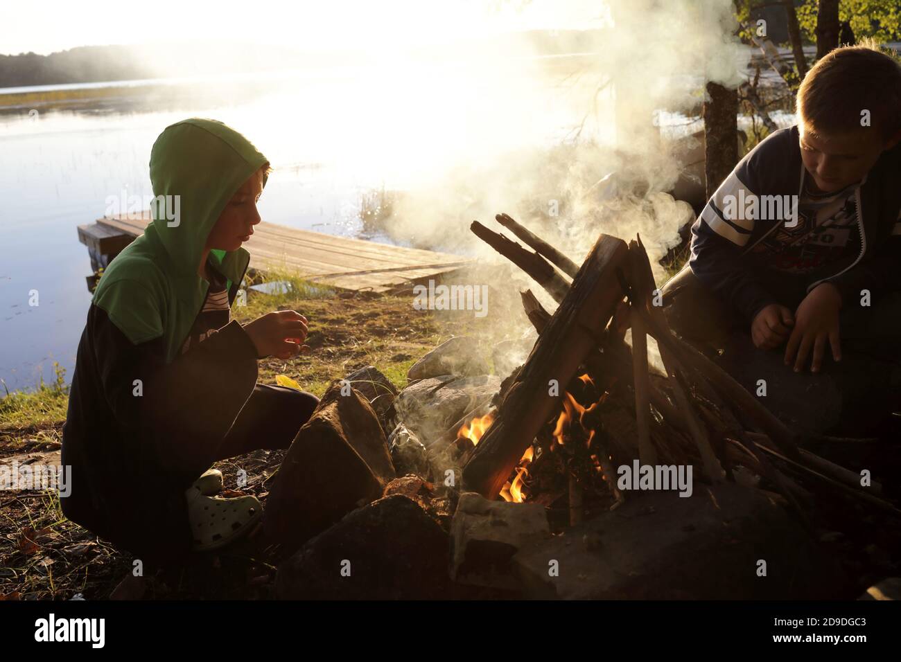 Children by fire in forest in evening, Karelia Stock Photo - Alamy