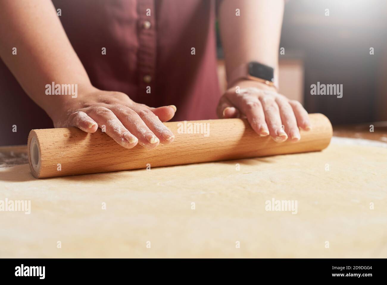 Female hands roll out the raw dough with a rolling pin Stock Photo - Alamy