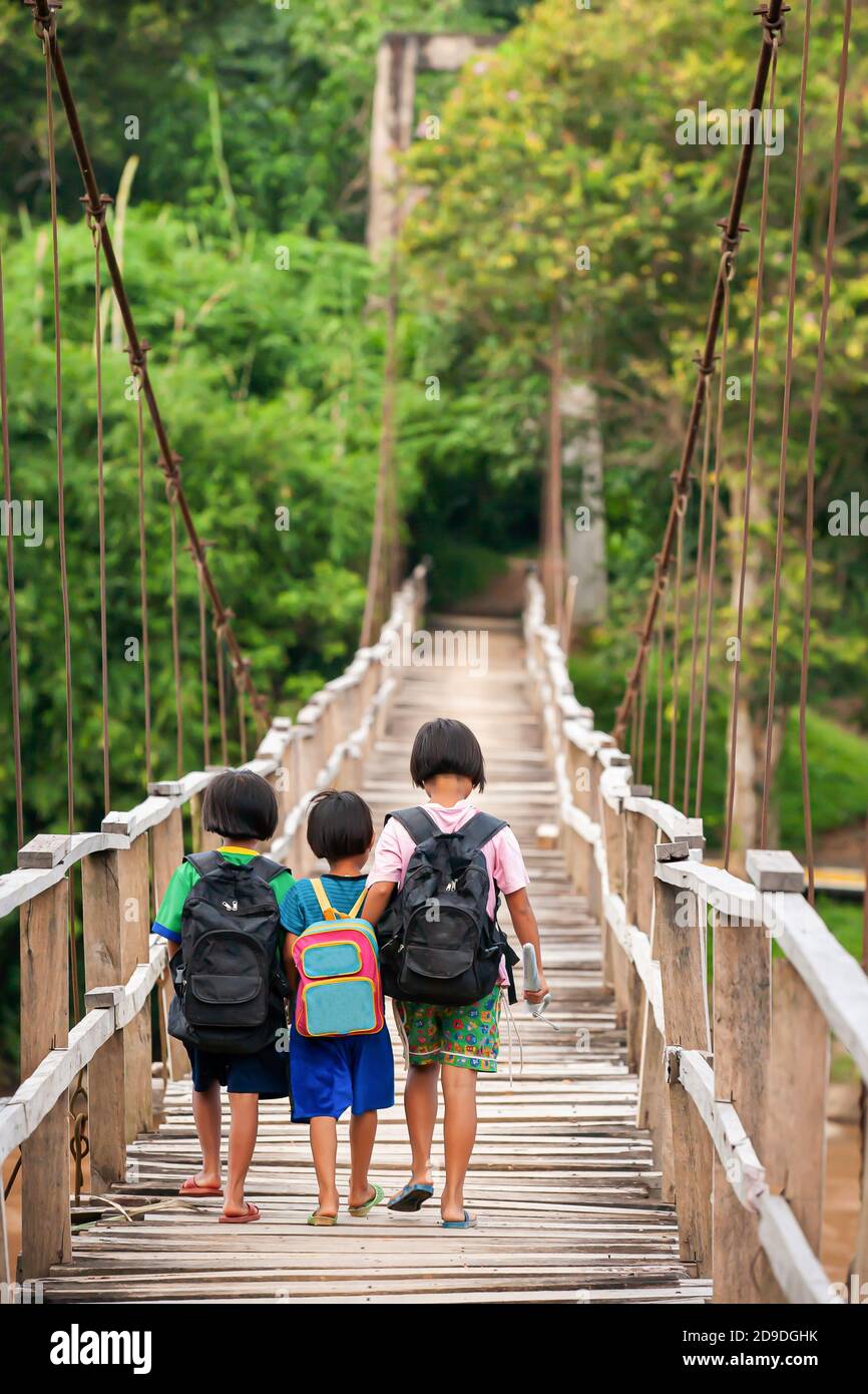 Asian primary school girls in casual clothes walking cross a simple ...