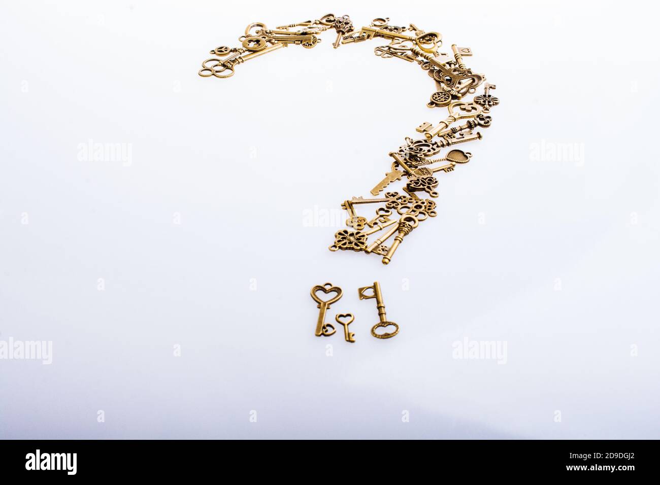 Closeup shot of little decorative keys laid out as a question mark ...