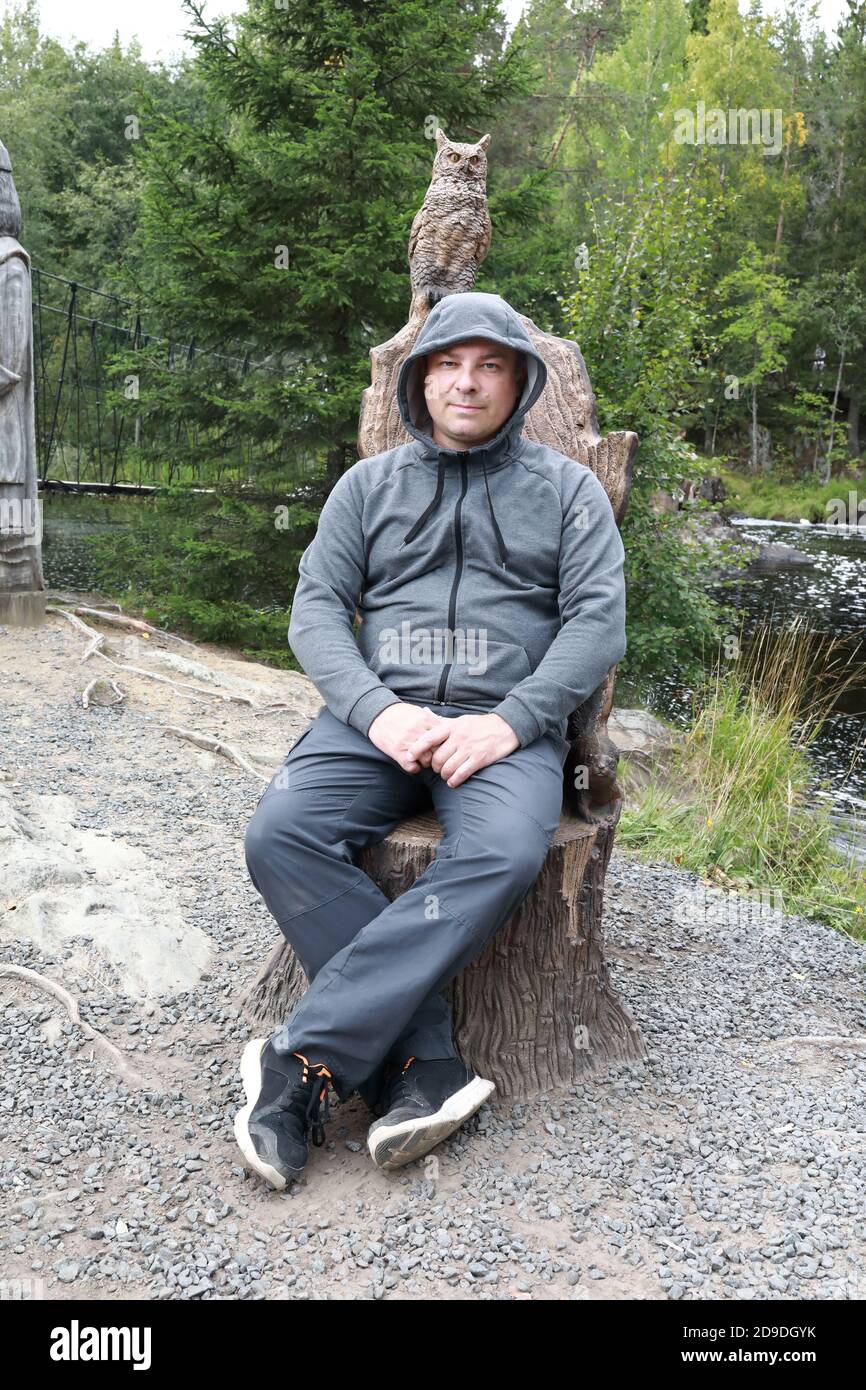 Man resting on stump chair in park, Karelia Stock Photo - Alamy