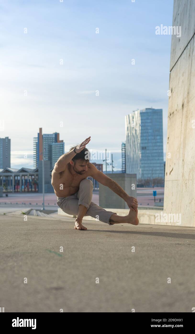 Man performing advanced yoga exercises and stretching to keep the body ...