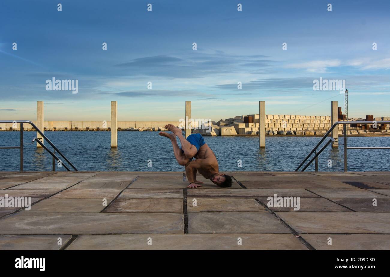Man performing advanced yoga exercises and stretching to keep the body ...