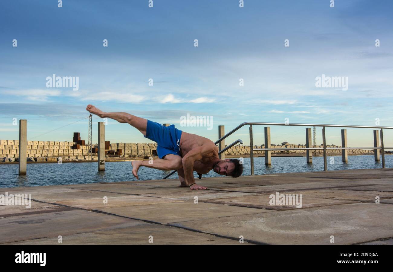 Man performing advanced yoga exercises and stretching to keep the body ...