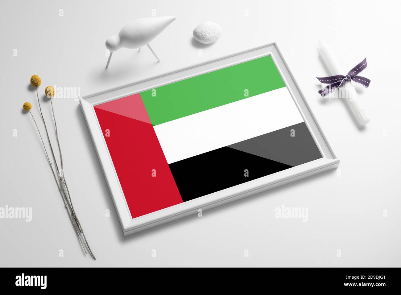 United Arab Emirates flag in wooden frame on table. White natural soft ...