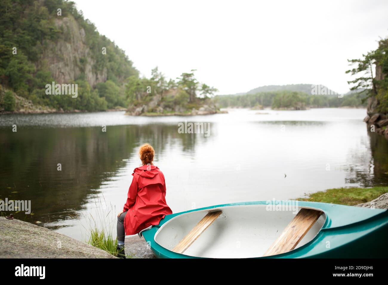 Portrait from behind of woman sitting on kayak by water Stock Photo - Alamy