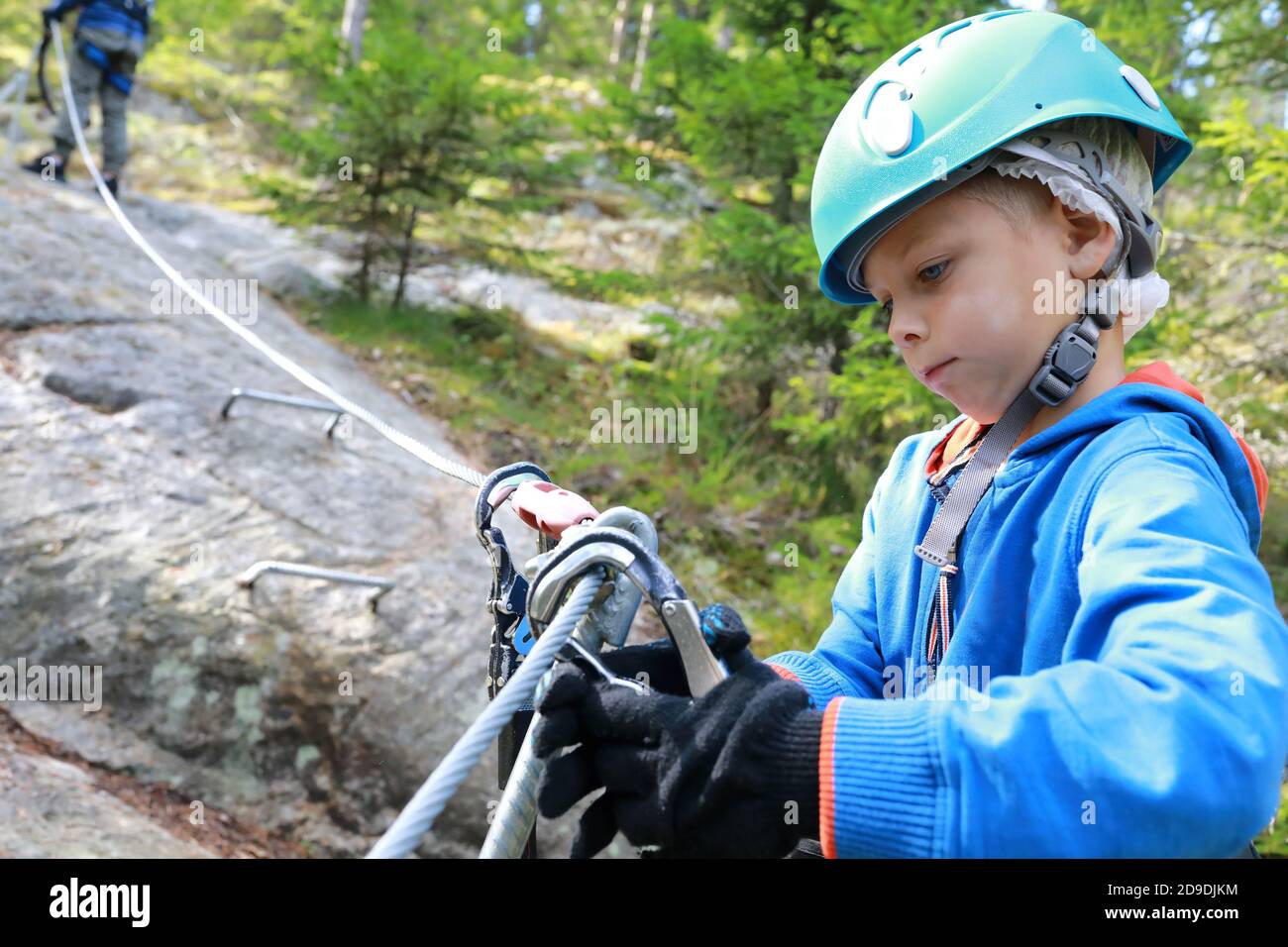 Kid using safety climbing equipment in forest adventure park Stock ...