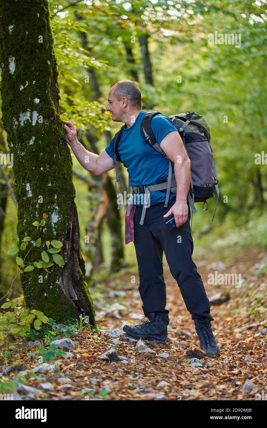 Active man with backpack hiking into the wilderness Stock Photo - Alamy