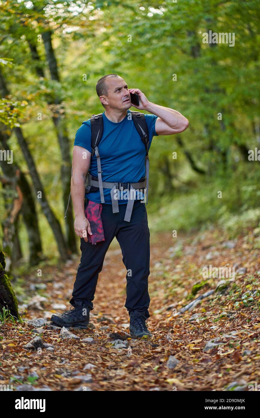 Hiker with backpack asking for directions, being lost in the woods ...