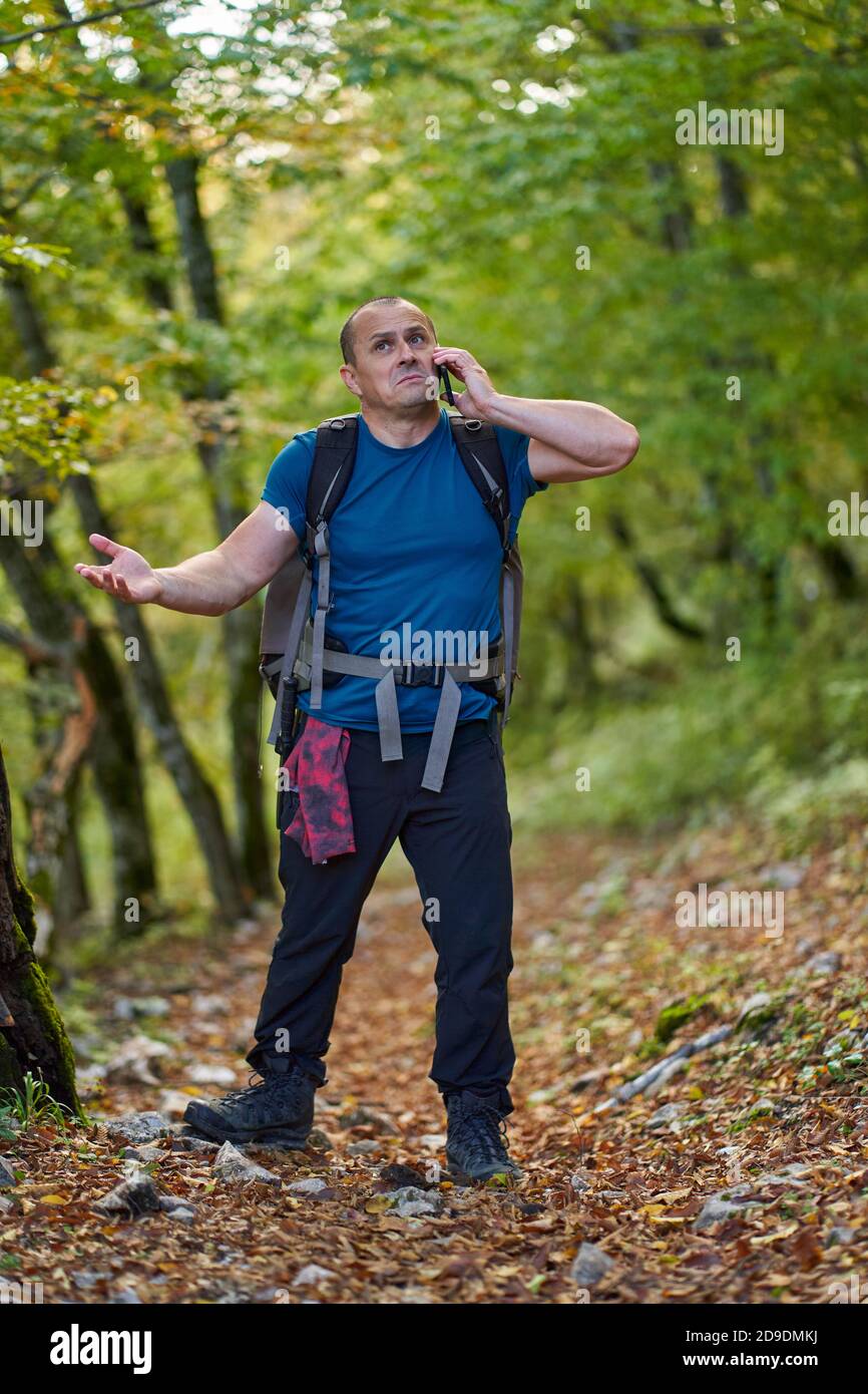 Hiker with backpack asking for directions, being lost in the woods ...
