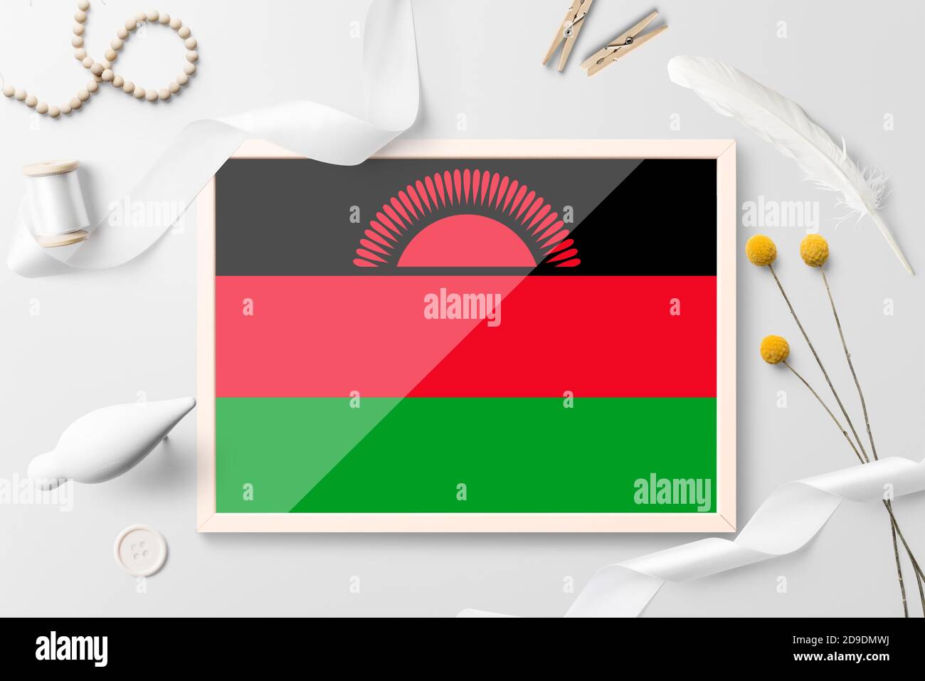 Malawi flag in wooden frame on white creative background. White theme ...