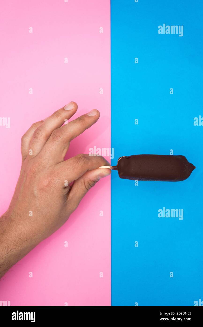 hand holding a chocolate and mint ice cream, with two colors, blue and ...