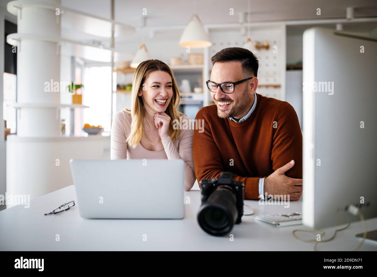 Graphic designers working in office with laptop. Team discussing ideas ...