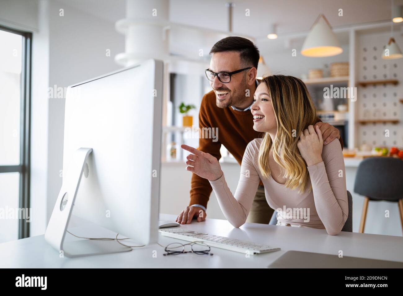 Positive couple having fun while working together remotely at home ...