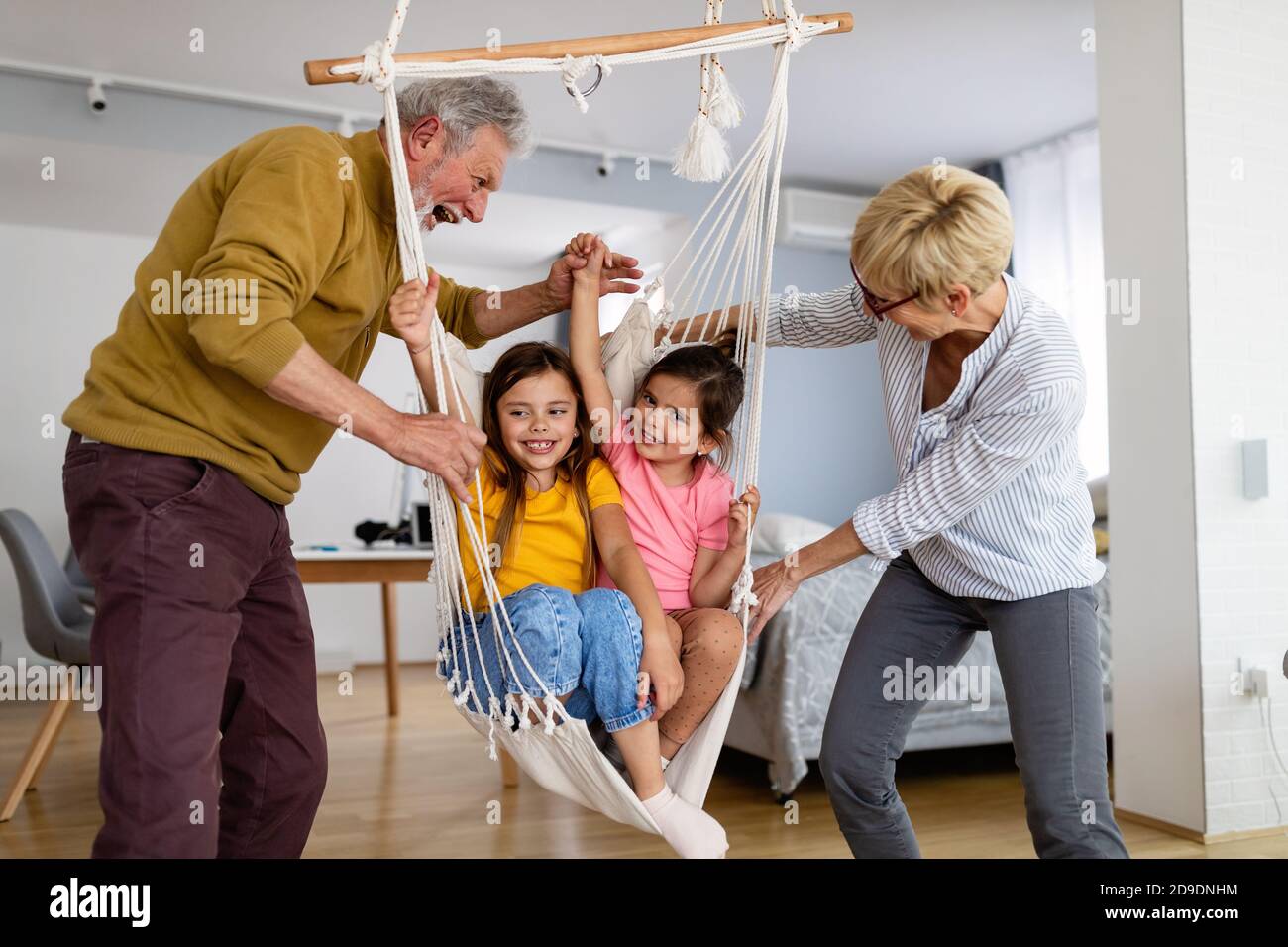 Grandchildren having fun at home while playing with their grandparents ...
