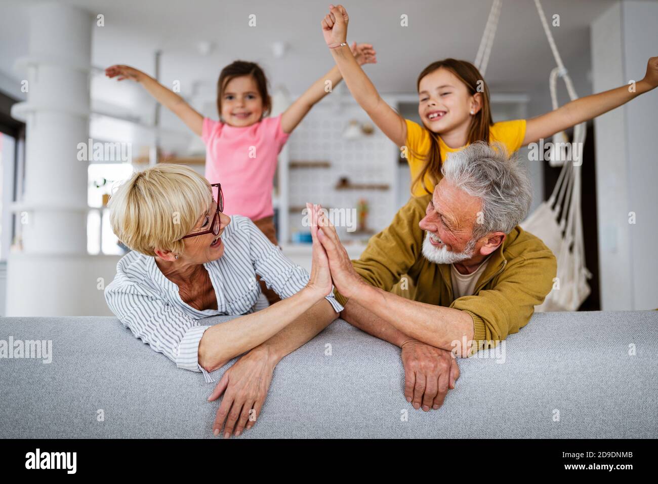 Grandchildren having fun at home while playing with their grandparents ...
