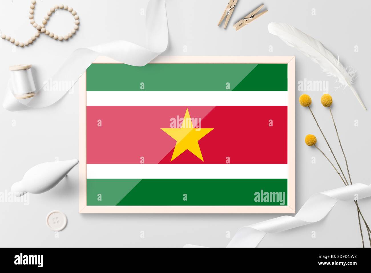 Suriname flag in wooden frame on white creative background. White theme ...