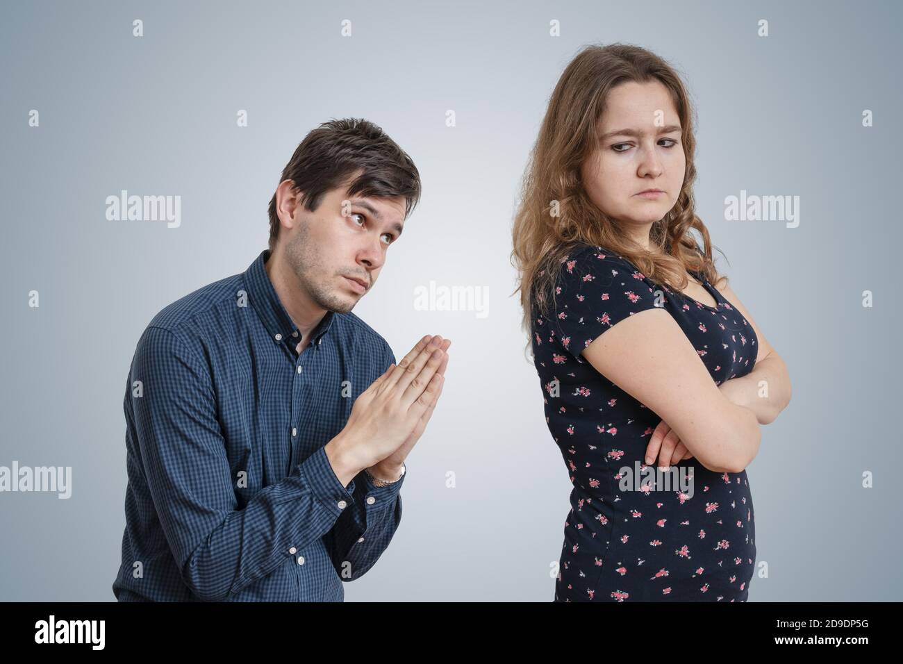 Young man is begging for forgiveness young angry woman Stock Photo - Alamy