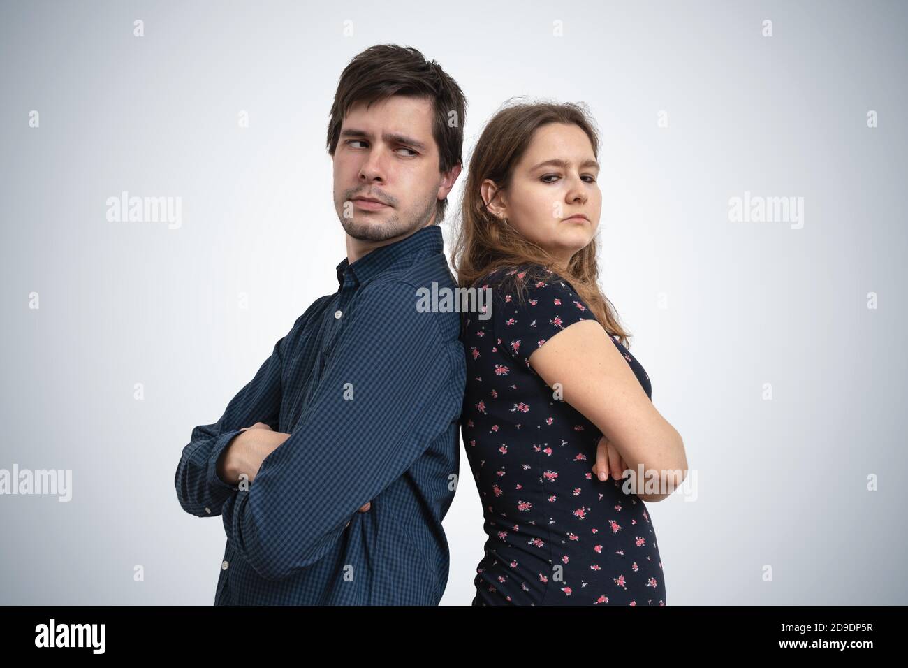 Young couple have problems. Upset man and woman standing back to back ...