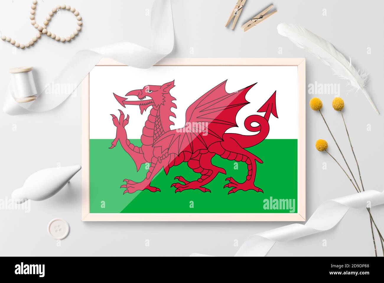 Wales flag in wooden frame on white creative background. White theme ...
