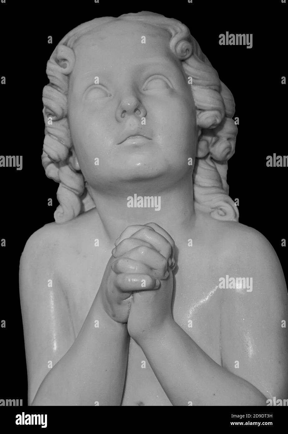 Boy statue pray to God with hands held together. Beautiful old stone ...