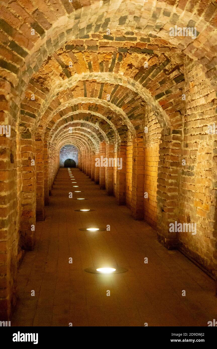 Brick archway made of red bricks as a passage between the two wings of ...