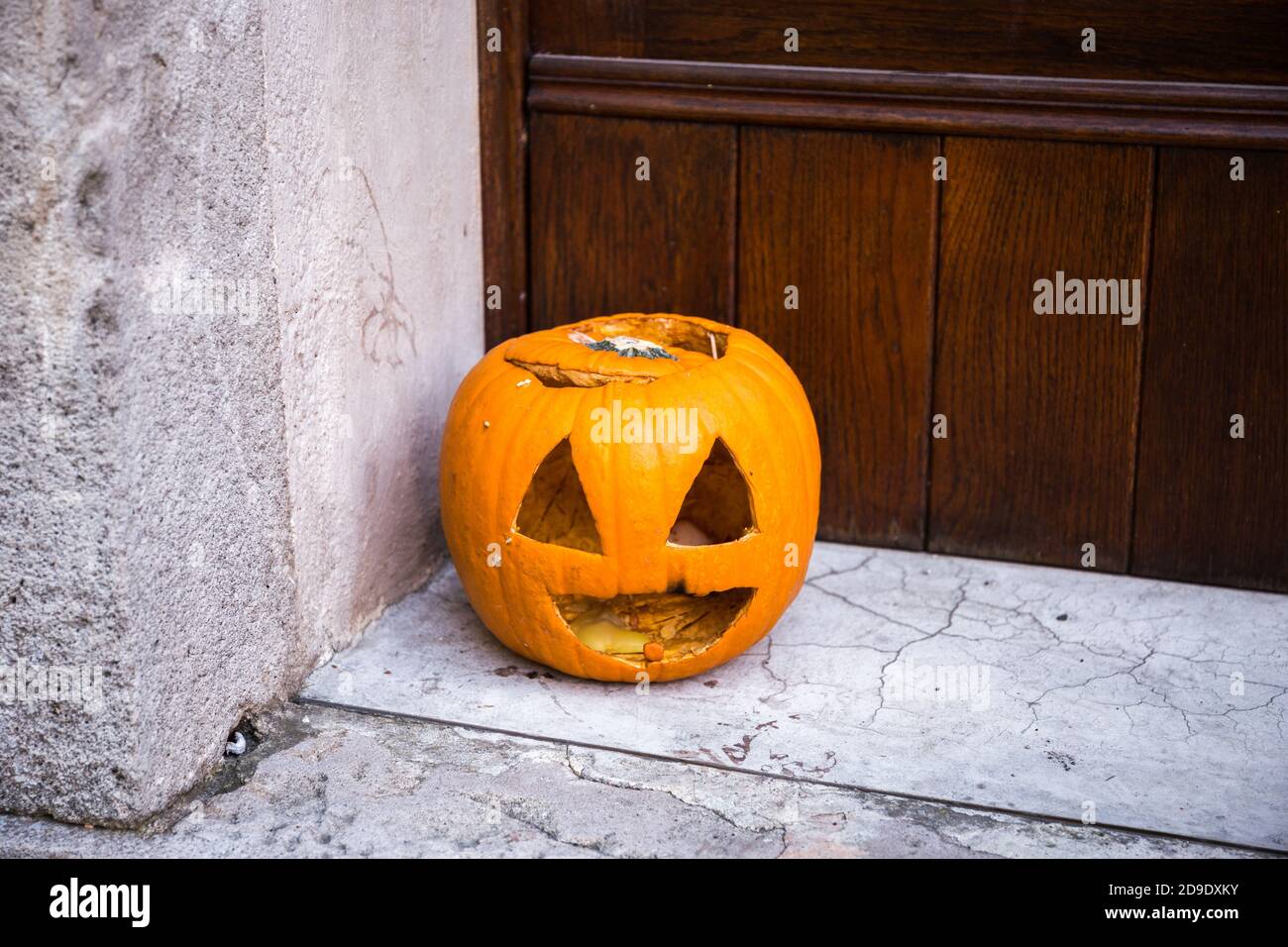Old damaged halloween pumpkin standing next to a wall Stock Photo - Alamy