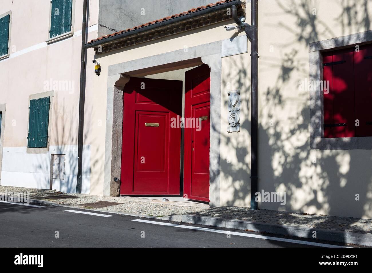Front of an old entrance red ajar gate on the street Stock Photo - Alamy