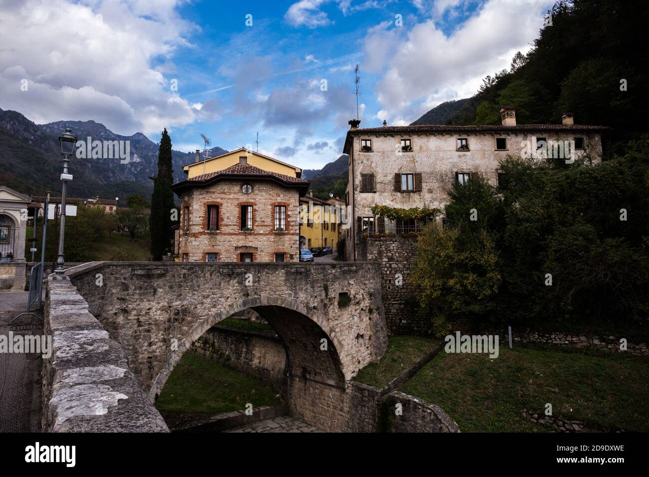 Old rural buildings with many windows, stone bridge and beautiful blue ...