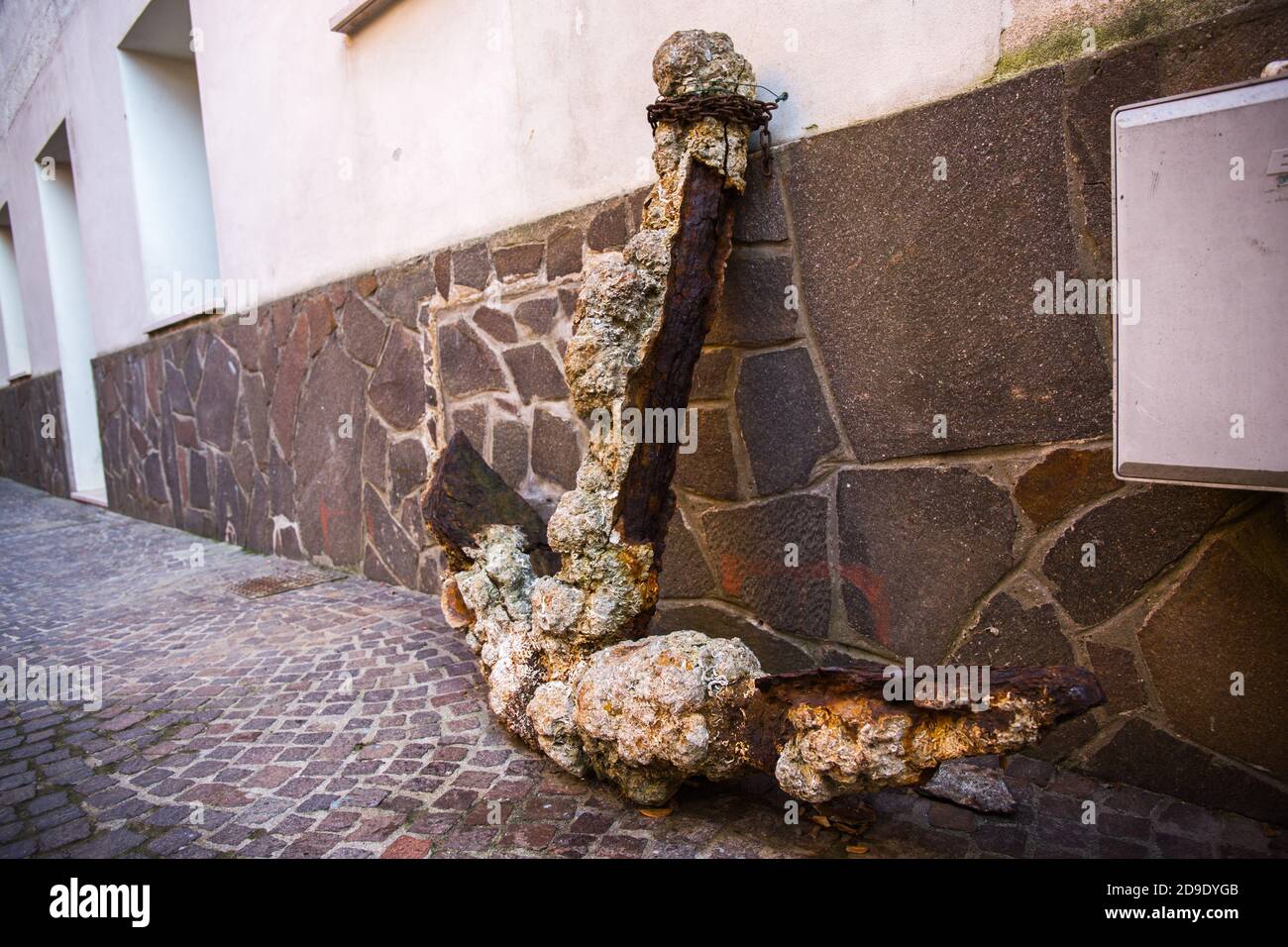 Stone ancient anchor standing near a wall of a building Stock Photo - Alamy