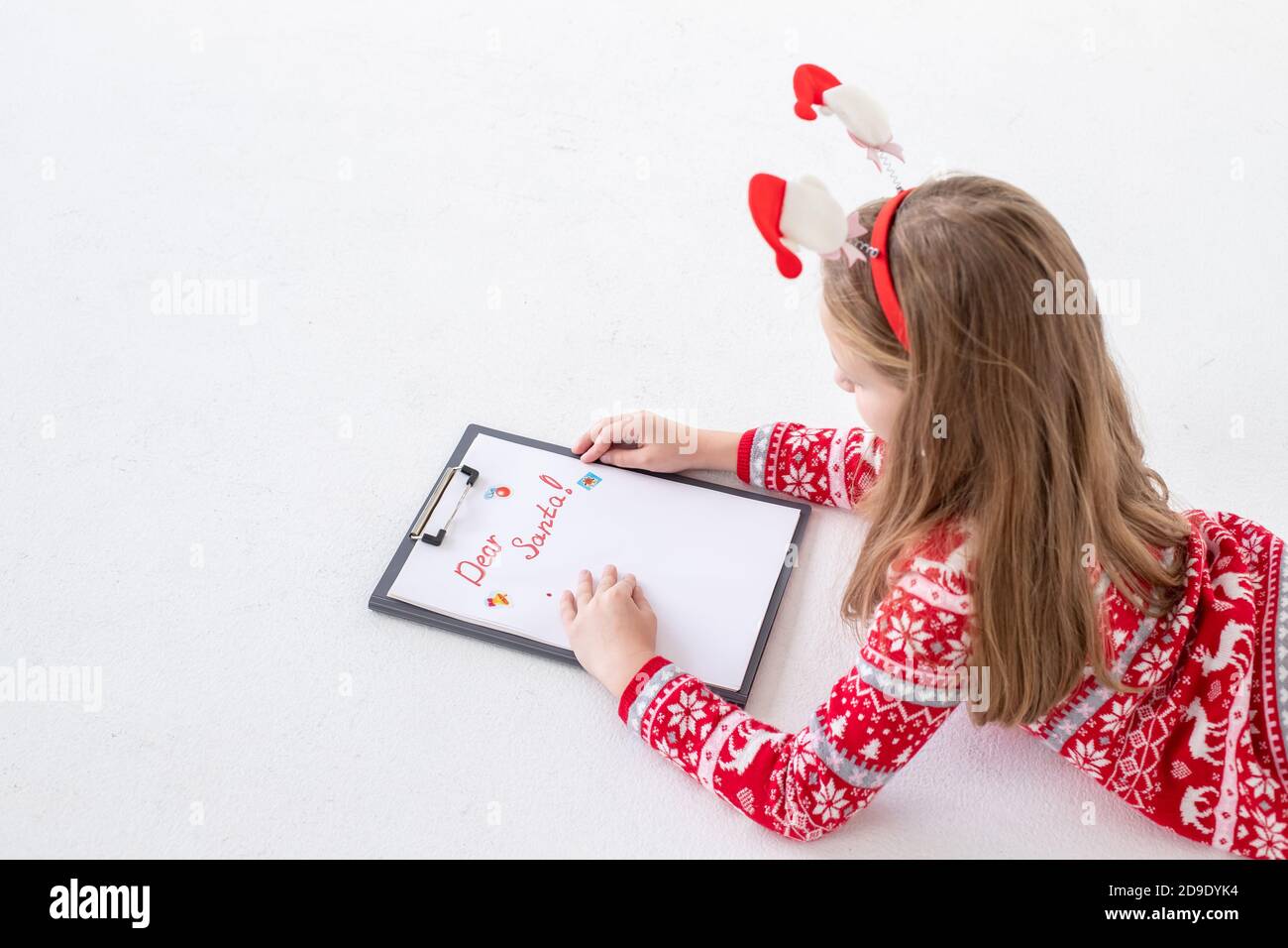 Child writing letter to Santa Claus at Christmas on white background ...