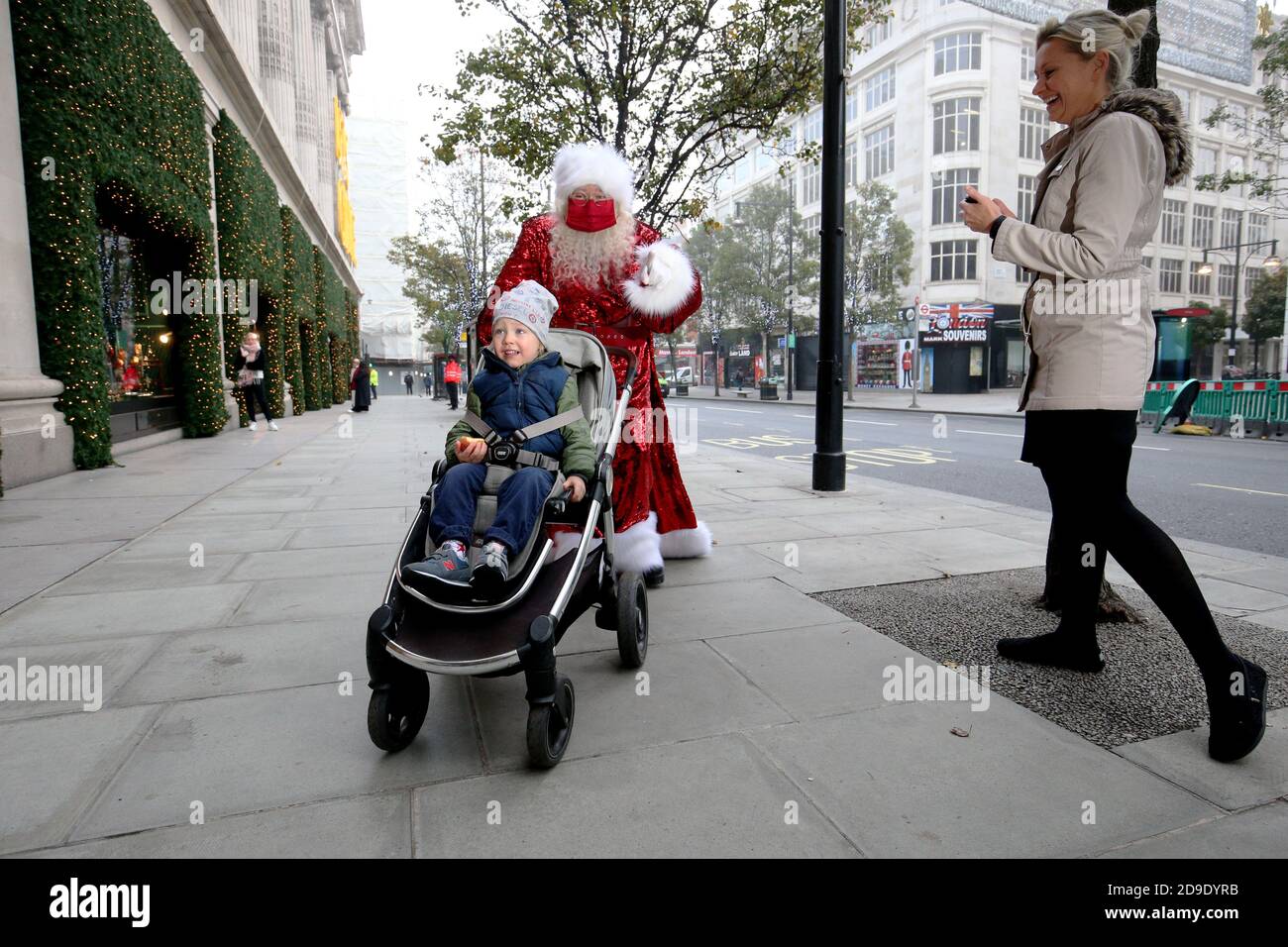 Selfridges' new look Santa pushes a young person in a perambulator as ...