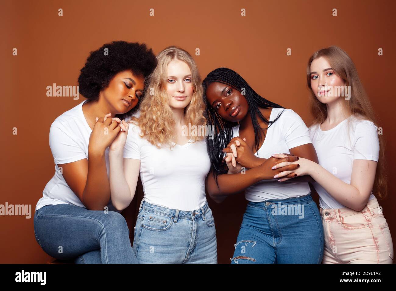young pretty caucasian, afro, scandinavian woman posing cheerful together on brown background ...