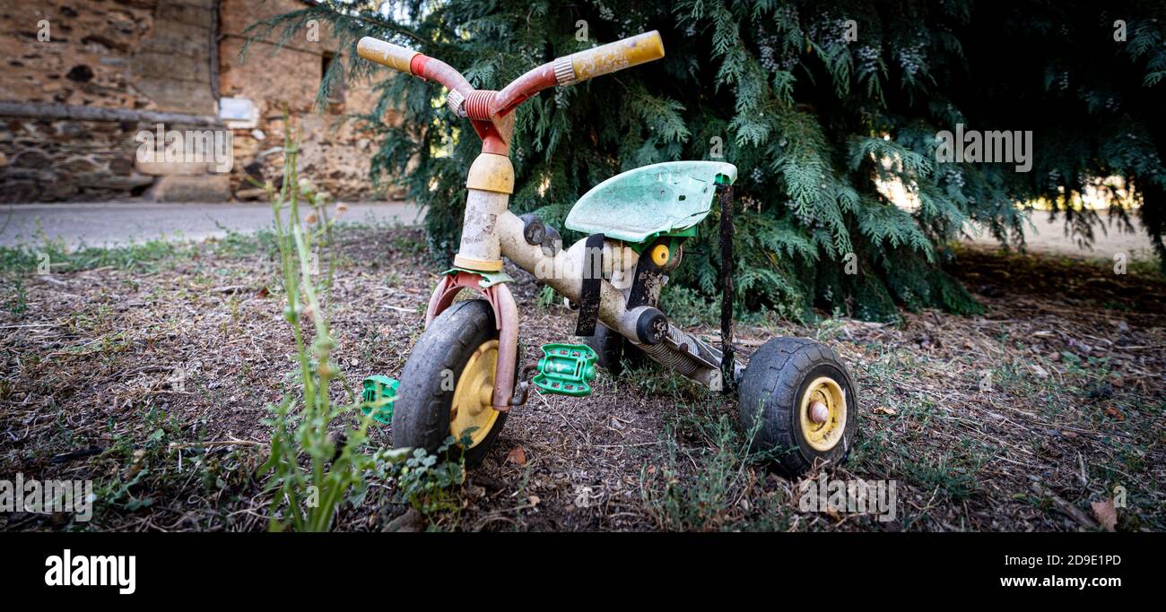 Old abandoned and rusty tricycle closeup view Stock Photo - Alamy