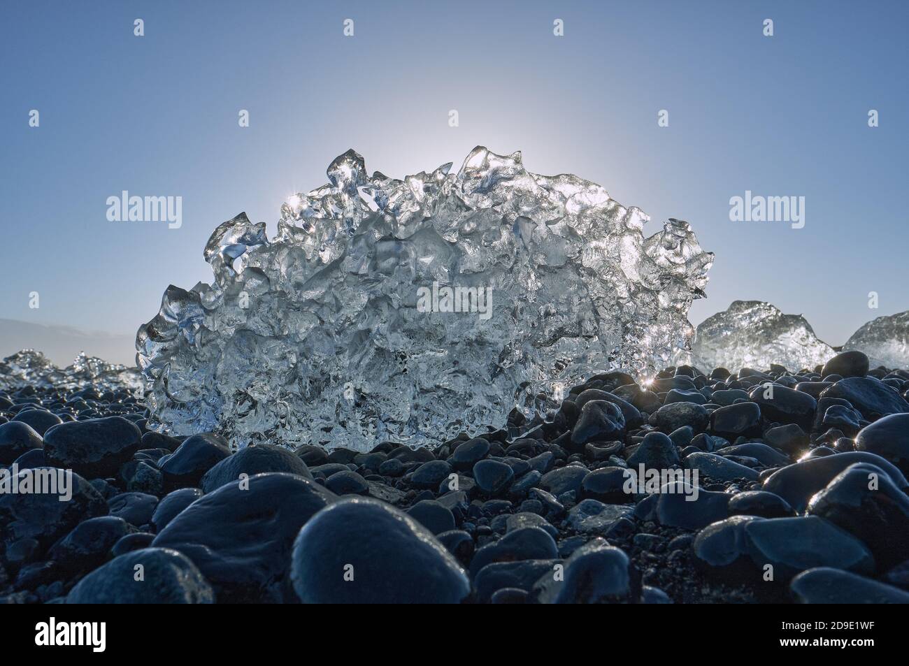 Melting glacial iceberg fragments on the black basalt pebble beach of ...