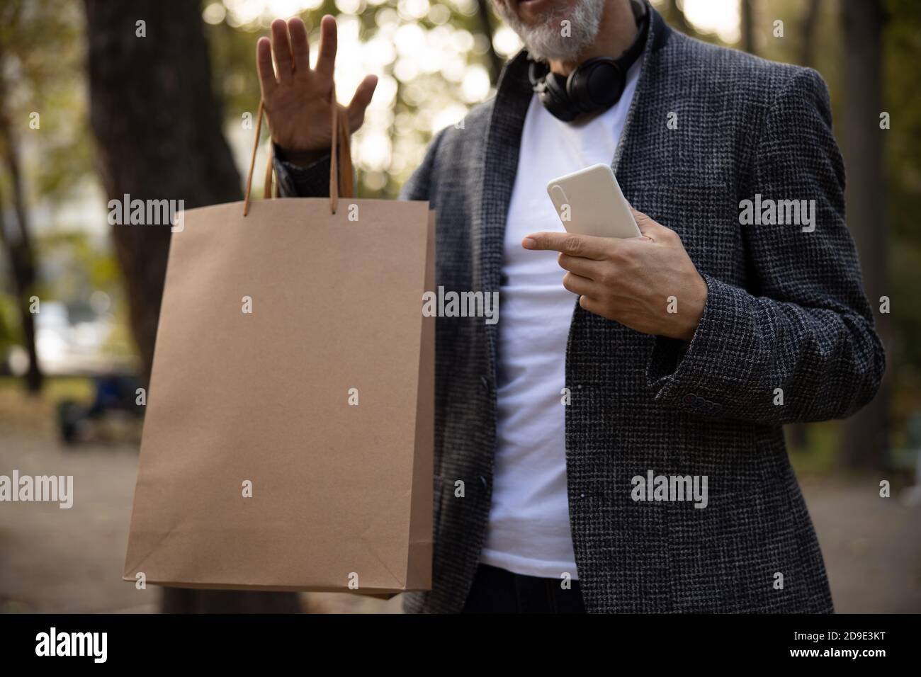 Elegant man walking in park after shopping Stock Photo - Alamy