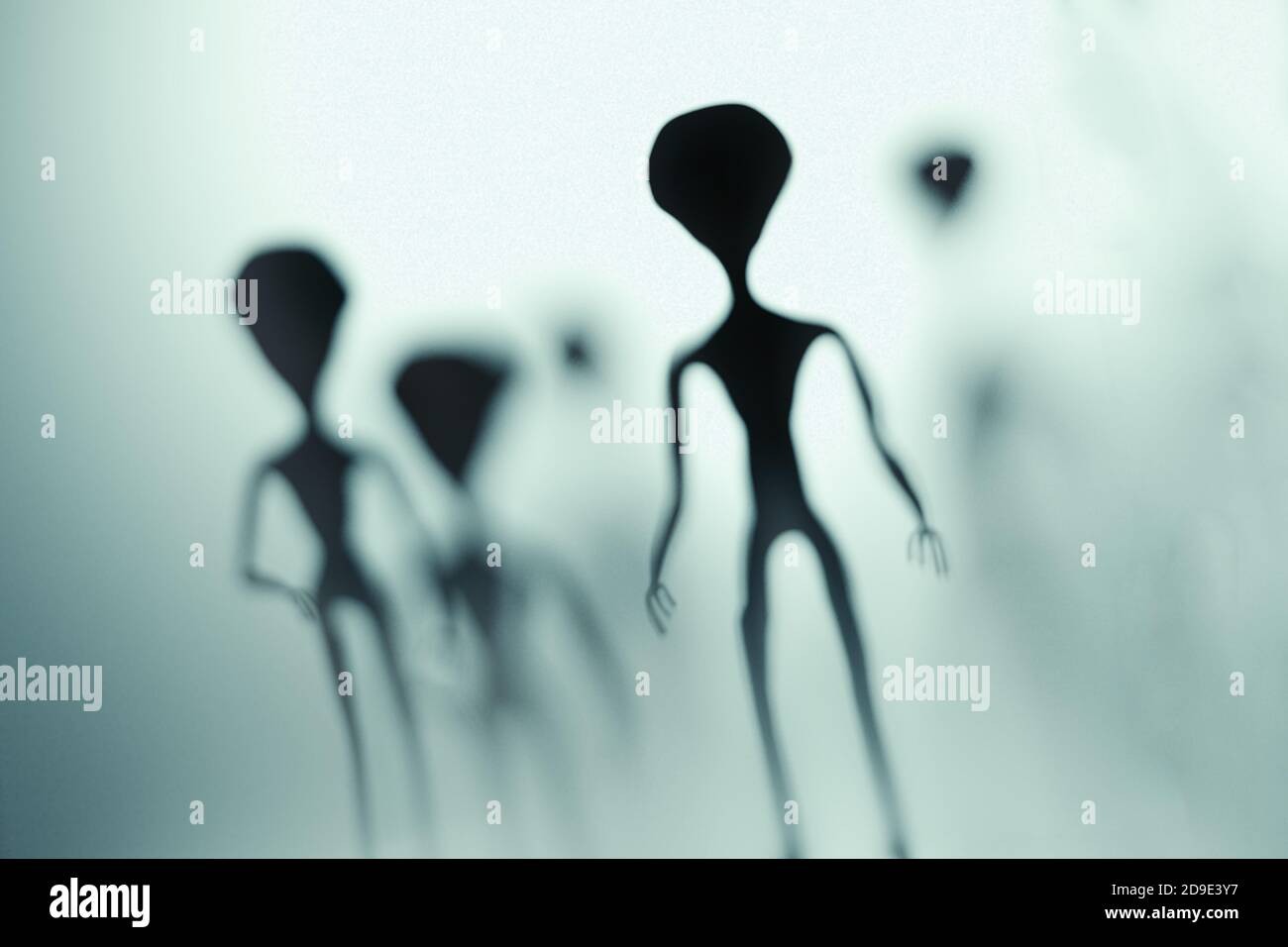 Spooky silhouettes of aliens and bright light in background. 3D ...