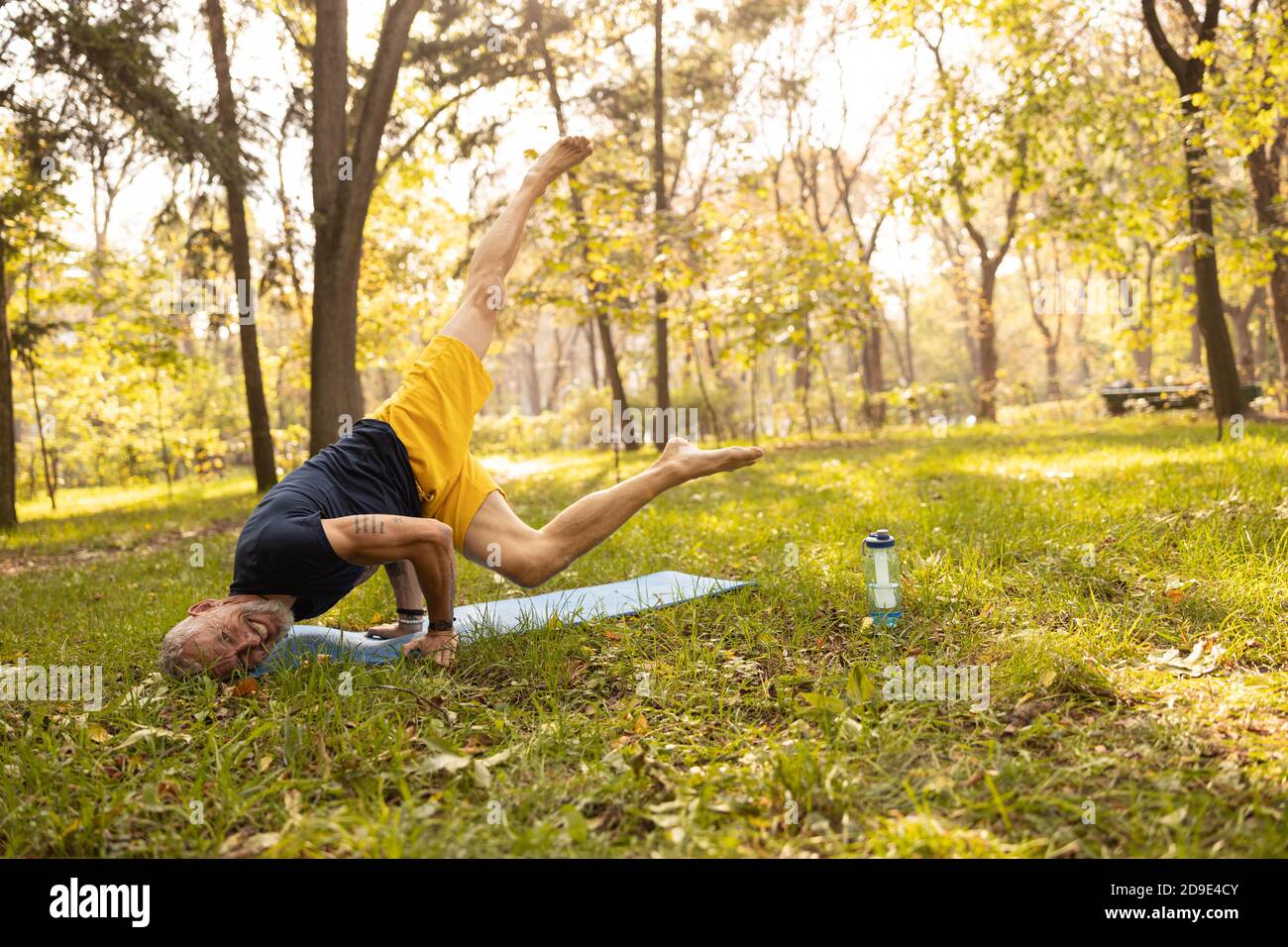 Fit male doing balance asana in nature Stock Photo - Alamy